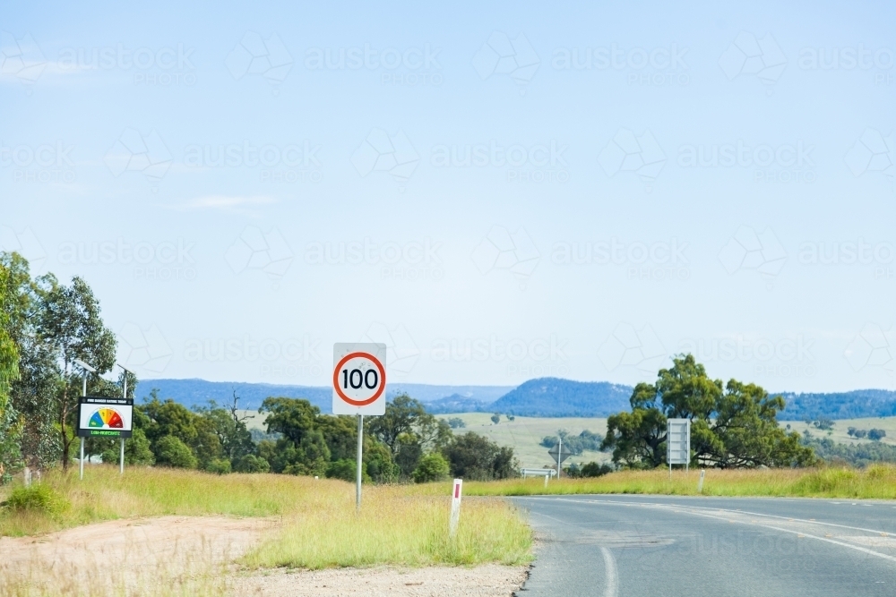 Image of 100 max speed sign beside highway and fire danger rating sign ...