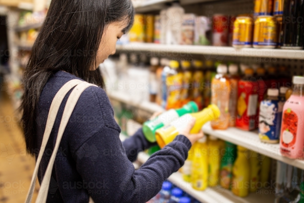 Image of 20-something Asian woman shopping buying groceries at a ...