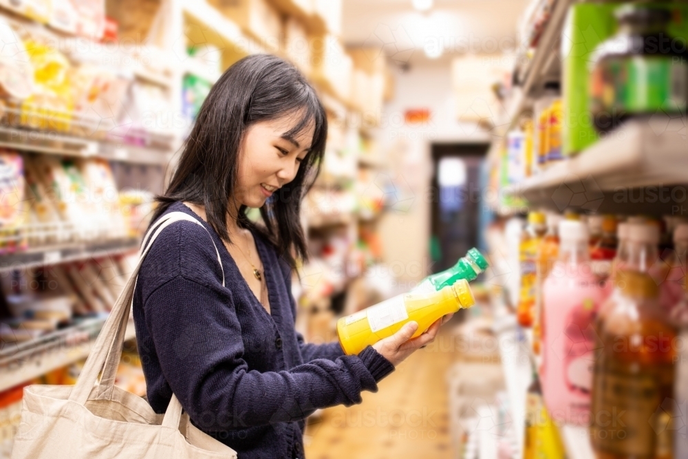 Image of 20-something Asian woman shopping buying groceries at a ...