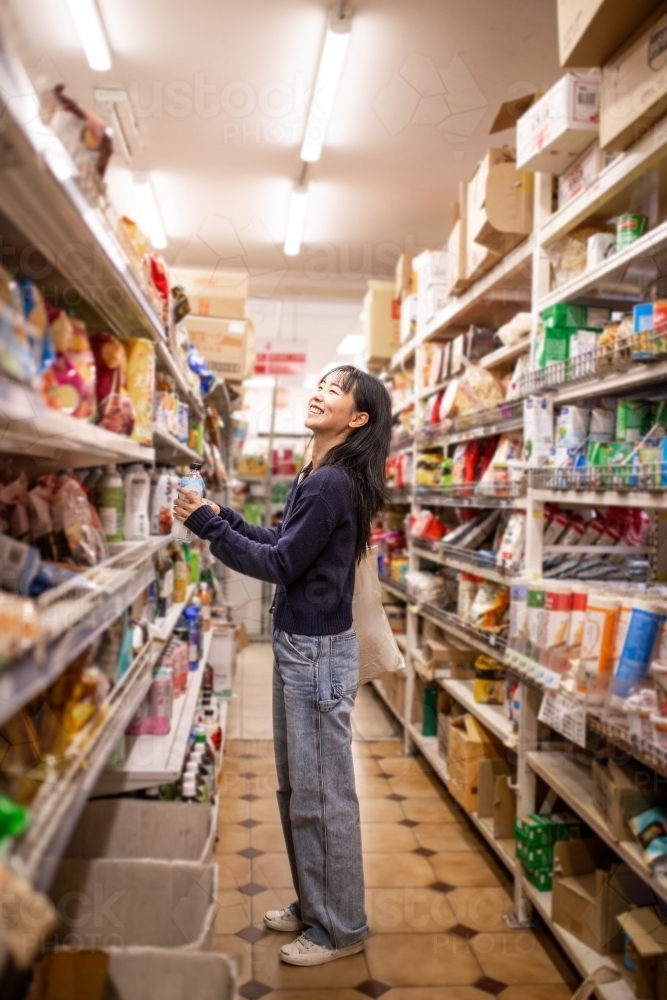Image of 20-something Asian woman shopping buying groceries at a ...