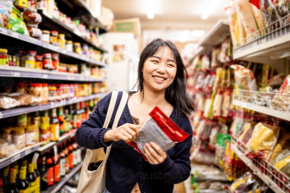 Image of 20-something Asian woman shopping buying groceries at a ...