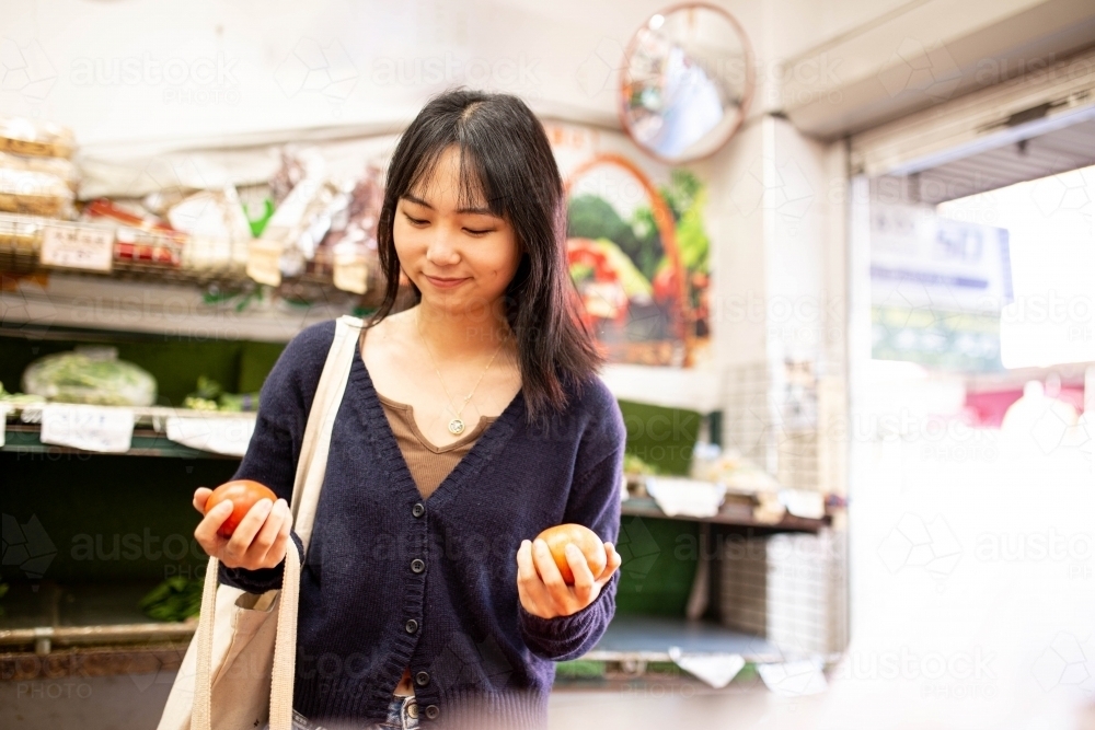 Image of 20-something Asian woman shopping buying groceries at a ...