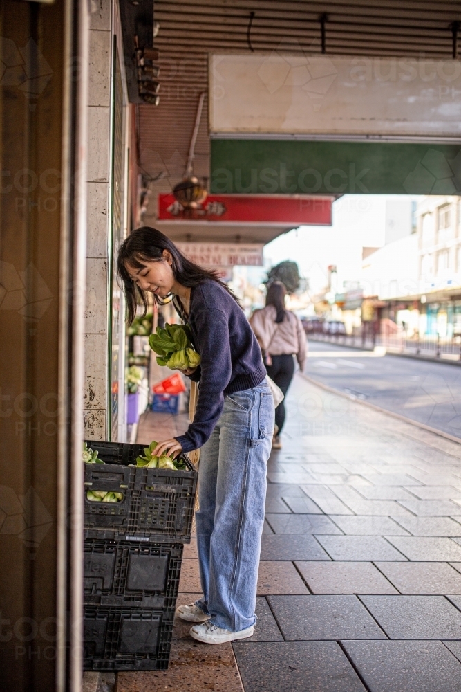 Image of 20-something Asian woman shopping buying groceries at a ...