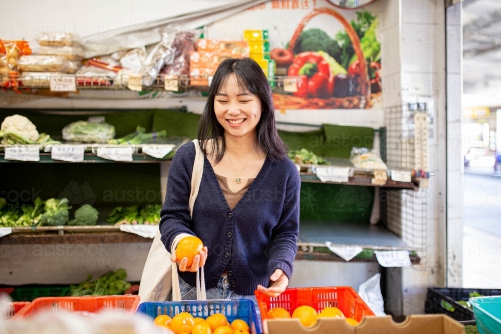 Image of 20-something Asian woman shopping buying groceries at a ...