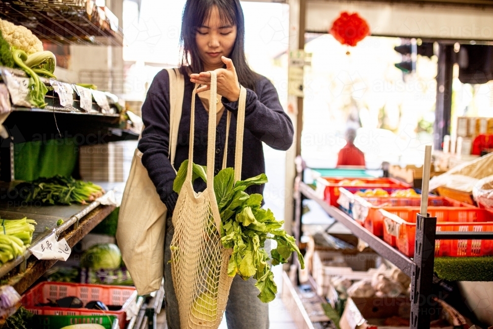 Image of 20-something Asian woman shopping buying groceries at a ...
