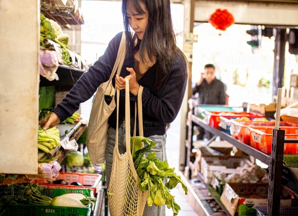 Image of 20-something Asian woman shopping buying groceries at a ...