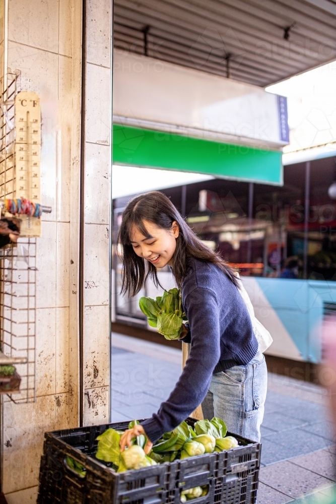Image of 20-something Asian woman shopping buying groceries at a ...