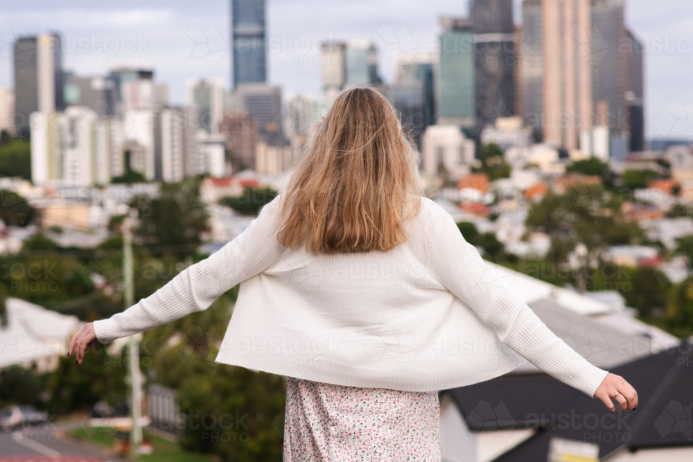 Image of 24 year old woman on a suburban street looking at the city ...