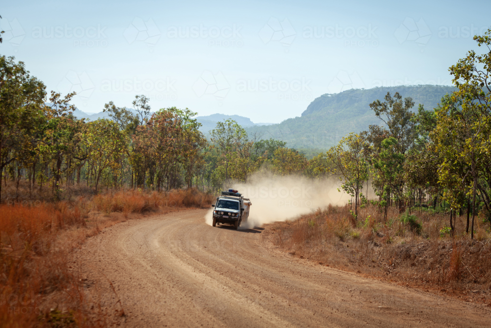 Image of 4 x 4 driving on dusty gravel road - Austockphoto
