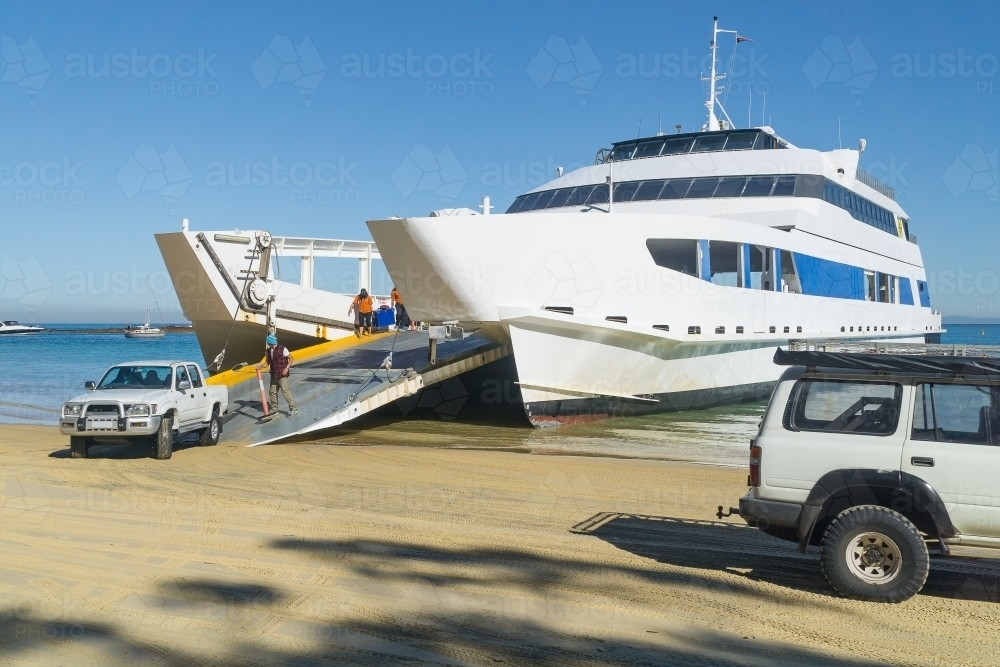 Image of 4WD's driving off a car ferry onto a beach - Austockphoto