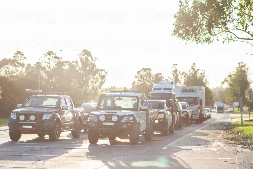 Image of 4x4 car and ute stopped at traffic light intersection backlit ...