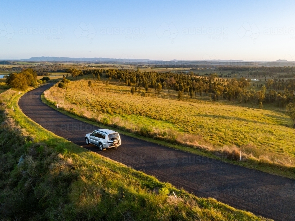 Image of 4x4 car driving on narrow country road at sunset - hope and ...