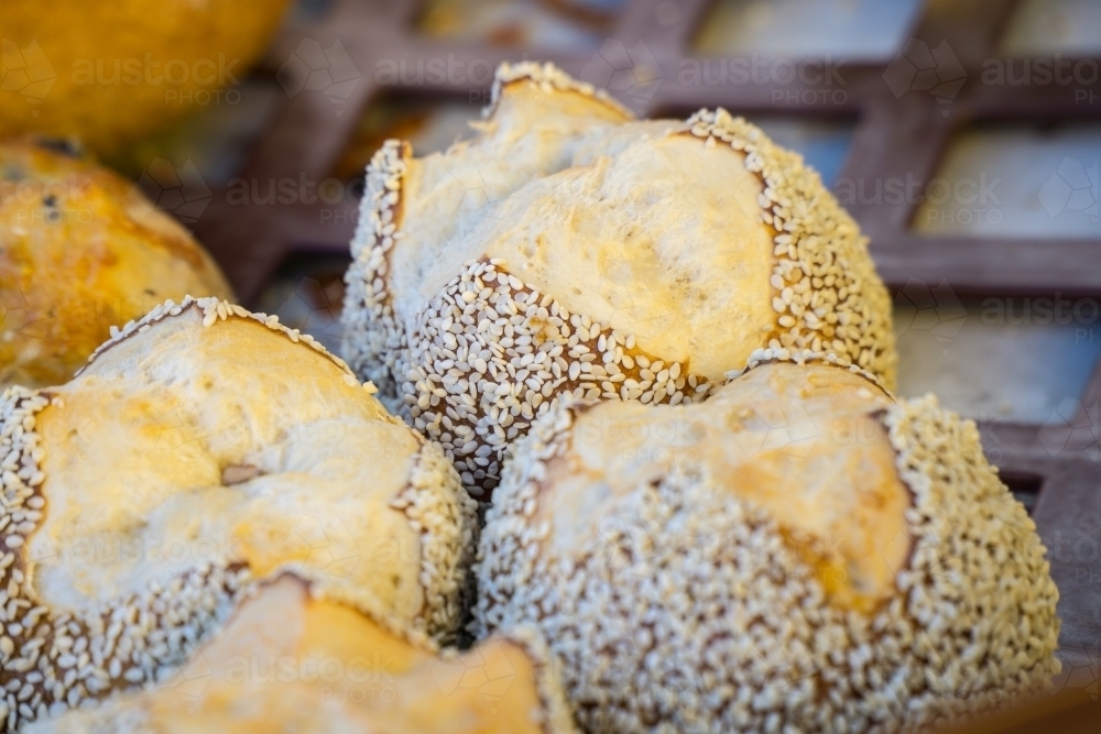 Image of A batch of lye bread rolls coated in sesame seeds - Austockphoto