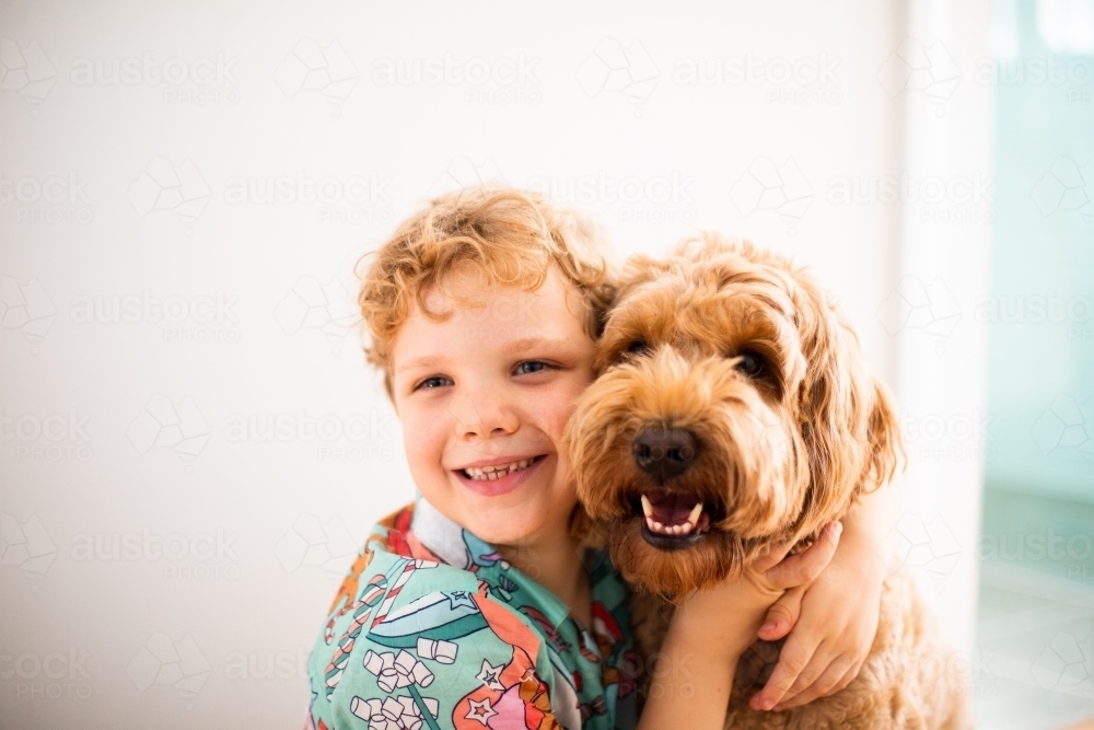 Image of a boy hugging his pet dog - Austockphoto