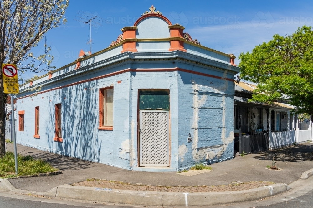 Image of A brightly coloured historic house on a suburban street corner ...