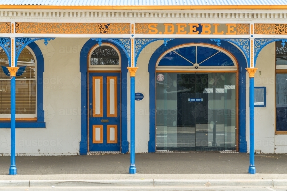 Image of A brightly painted old shop front and veranda - Austockphoto
