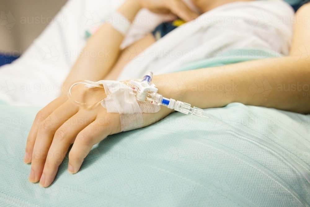 Image of A cannula in the left wrist of a female patient lying on a bed ...