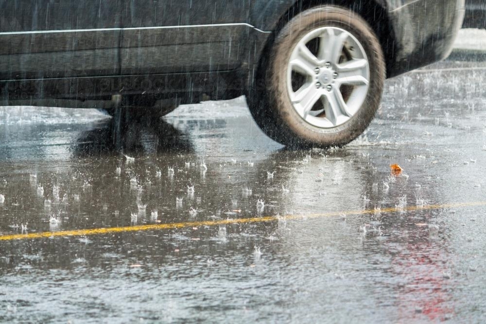 Image of A car on a wet road - Austockphoto