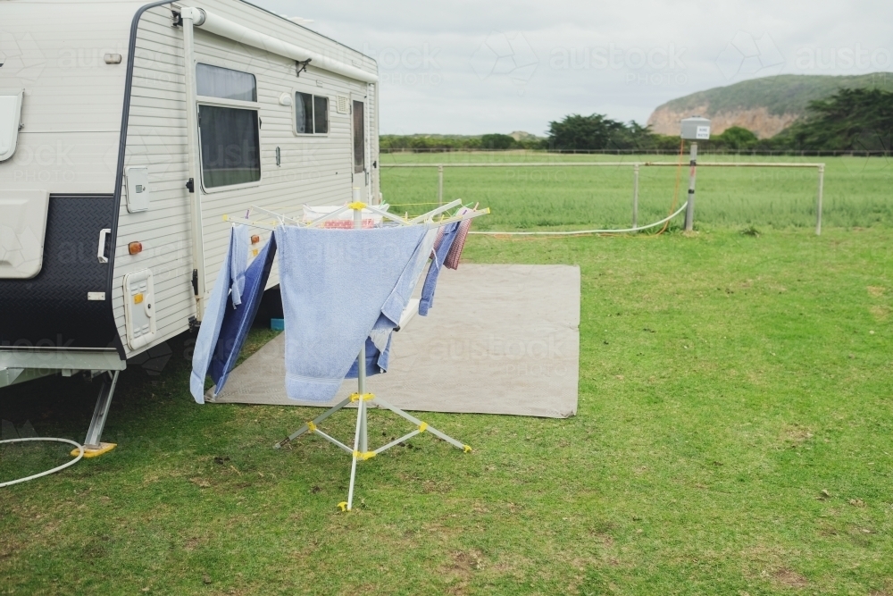 Image of A caravan and clothes on racks - Austockphoto