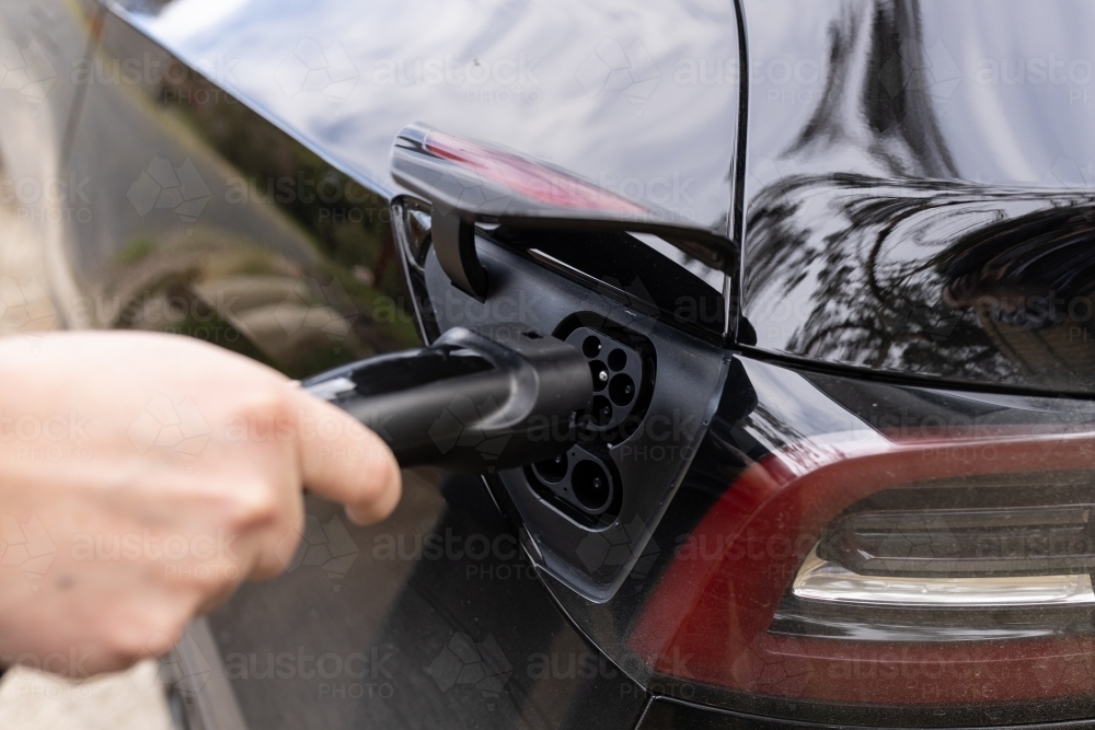 Image of A close up of a EV charger plug being plugged into an electric ...