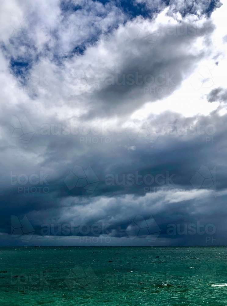 Image of A cold front storm approaches the coast, sea looks green ...