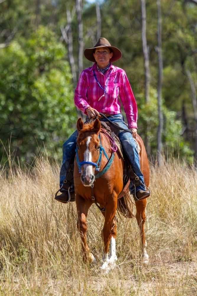 Image of A country lady in her sixties horse riding in the country ...