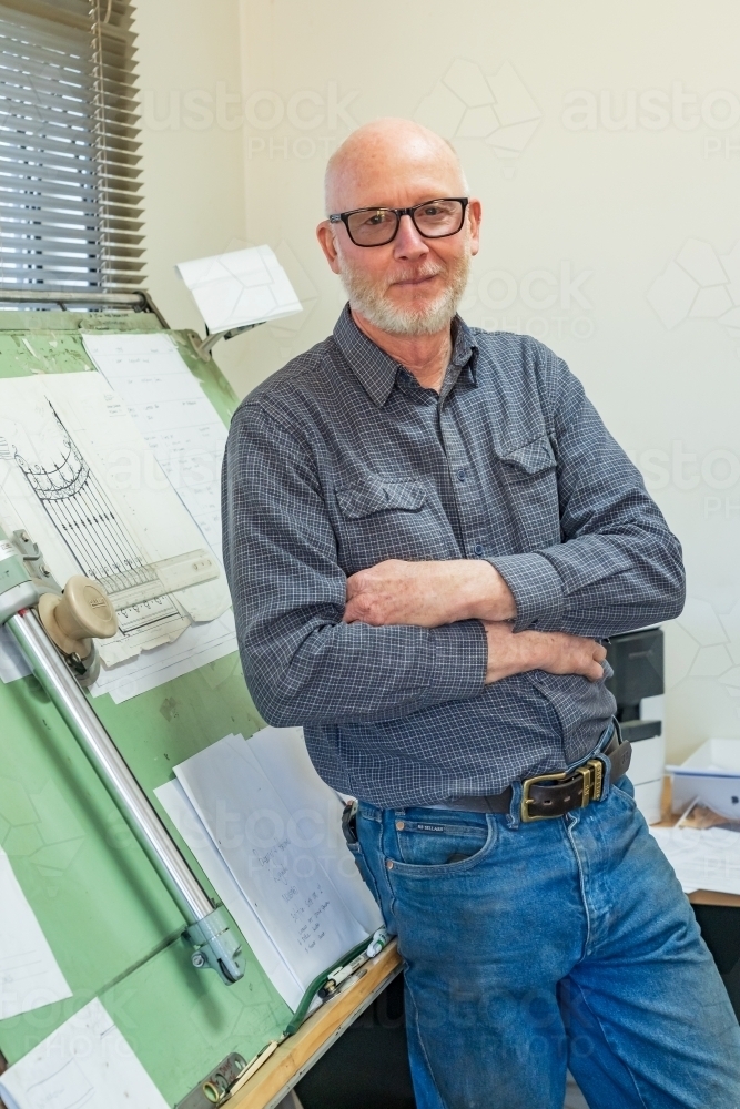 Image of A draftsman standing proudly in front of his drawing board ...
