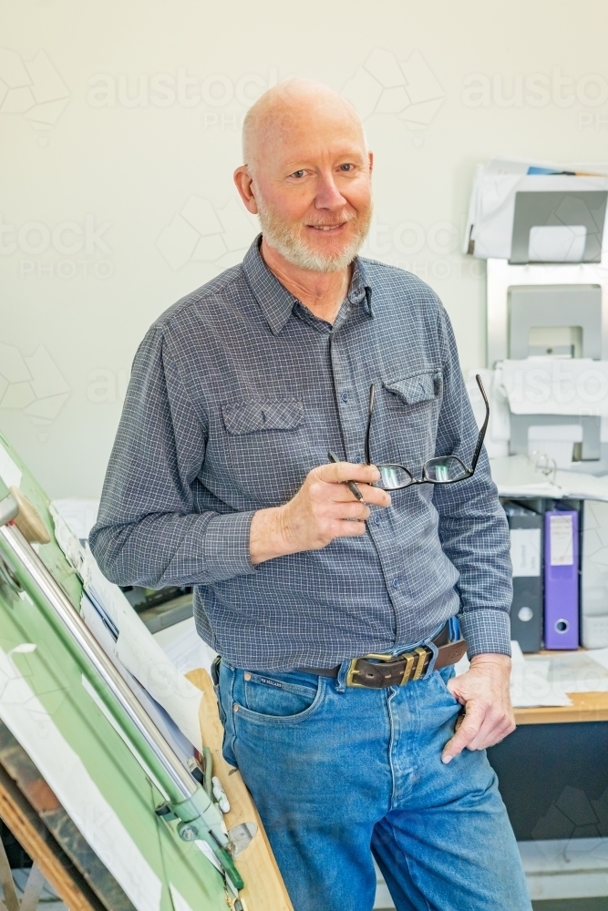 Image of A draftsman standing proudly in front of his drawing board ...