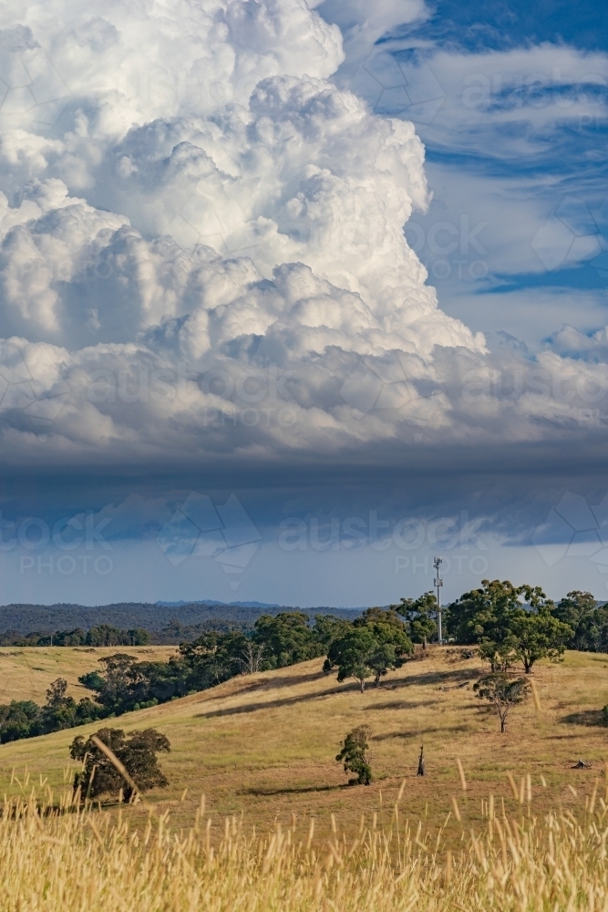 Image of A dramatic storm cloud building over dry rural hillside ...