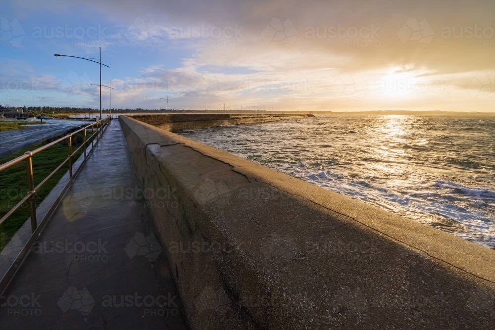 Image of A dramatic sunrise with a dark cloud bank over a coast ...
