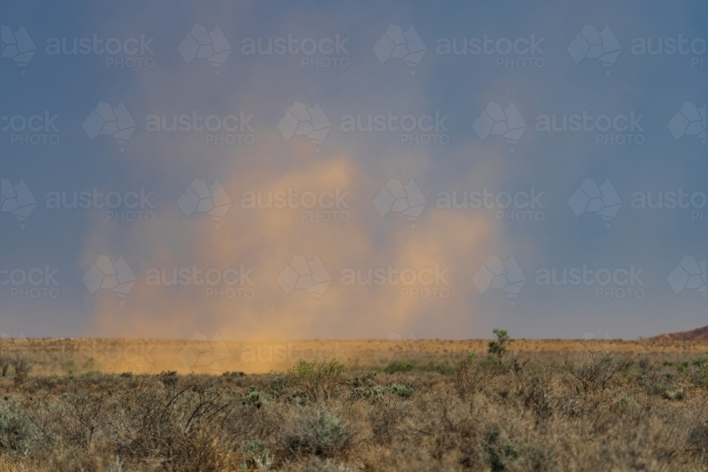 Image of A dust devil sweeping across an arid outback landscape ...