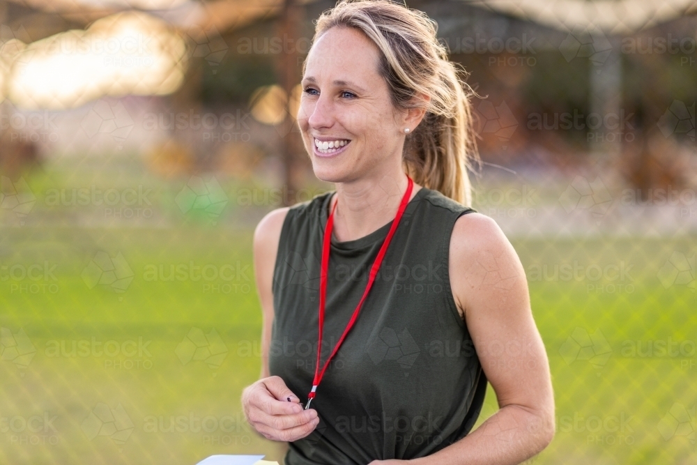 Image of a fit female coach with whistle on lanyard outdoors - Austockphoto