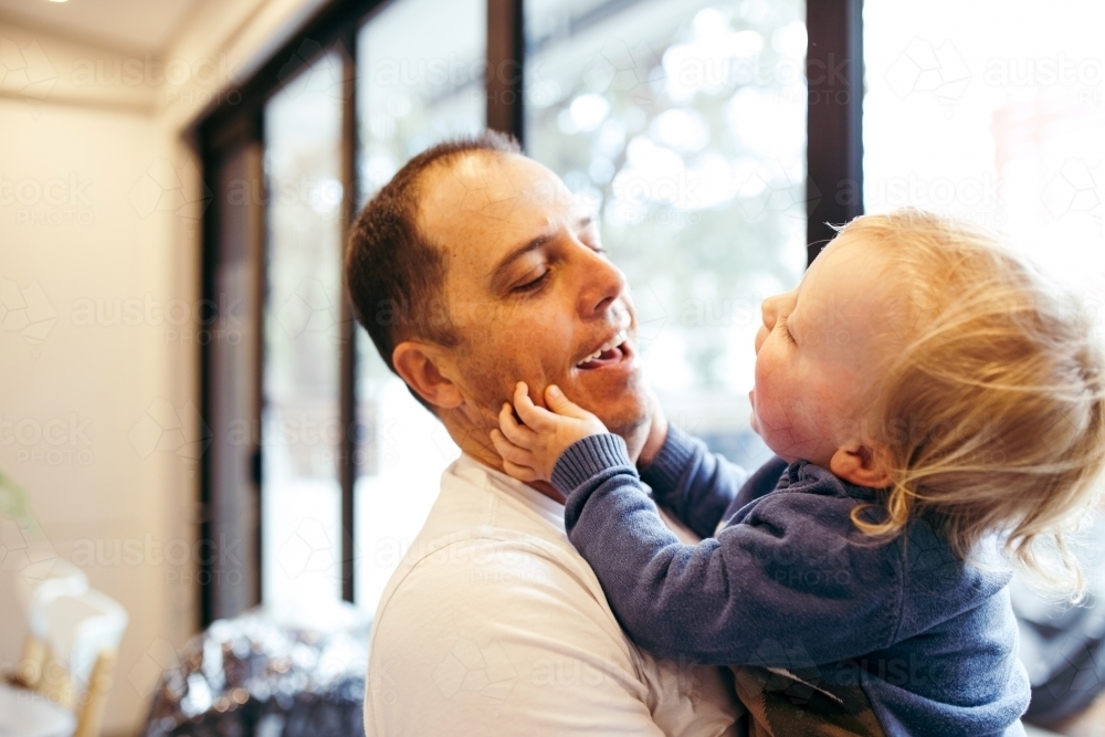 Image of a happy little boy laughing inside home with his dad ...