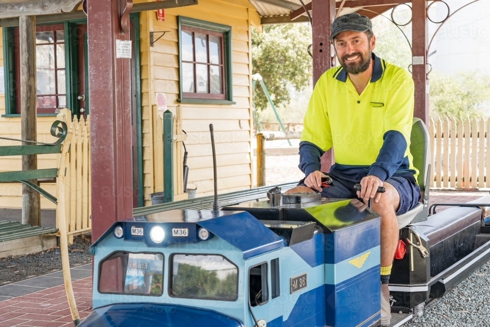 Image of A happy train driver sitting aboard the controls of a ...