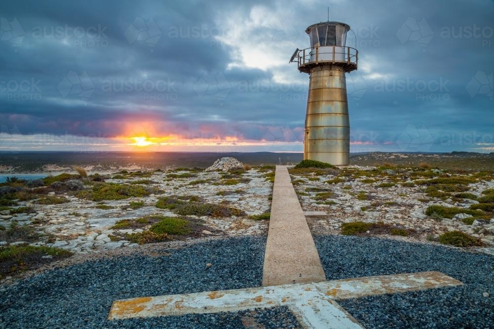 Image of A helipad and a lighthouse on a clifftop at sunrise - Austockphoto
