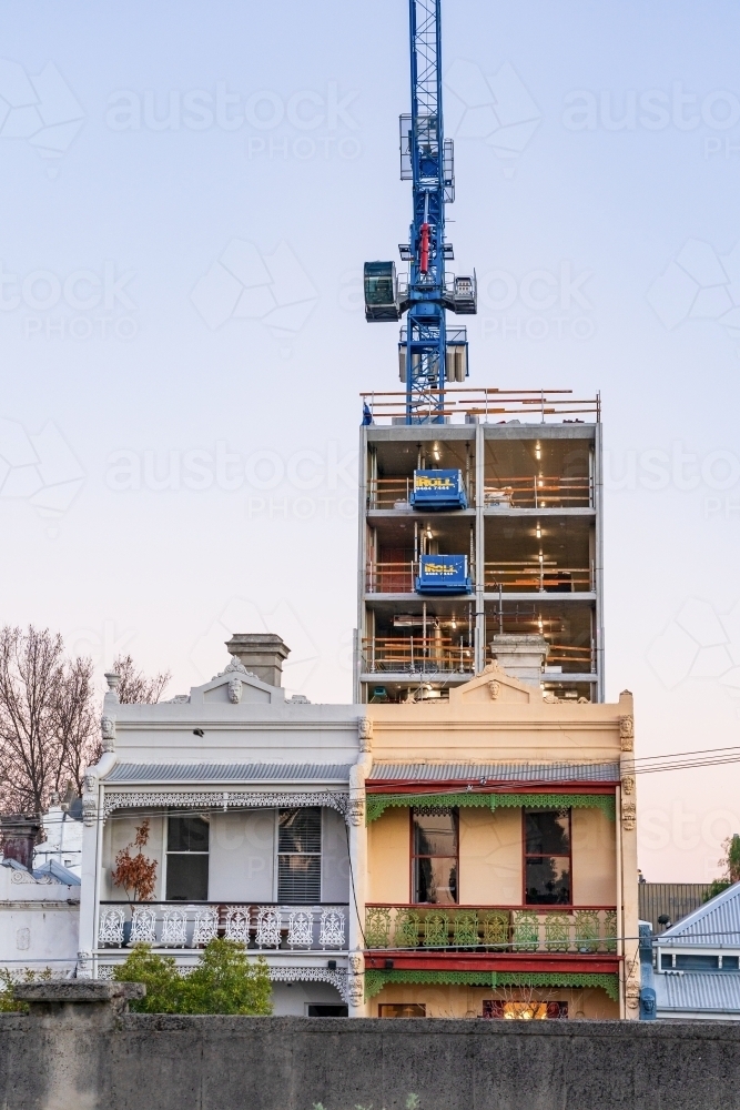 Image of A large construction crane on a high rise building behind two ...