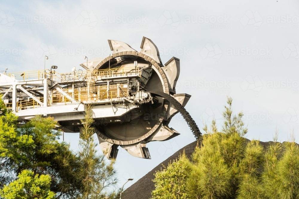 Image of A large continuous miner machine seen through the treetops ...