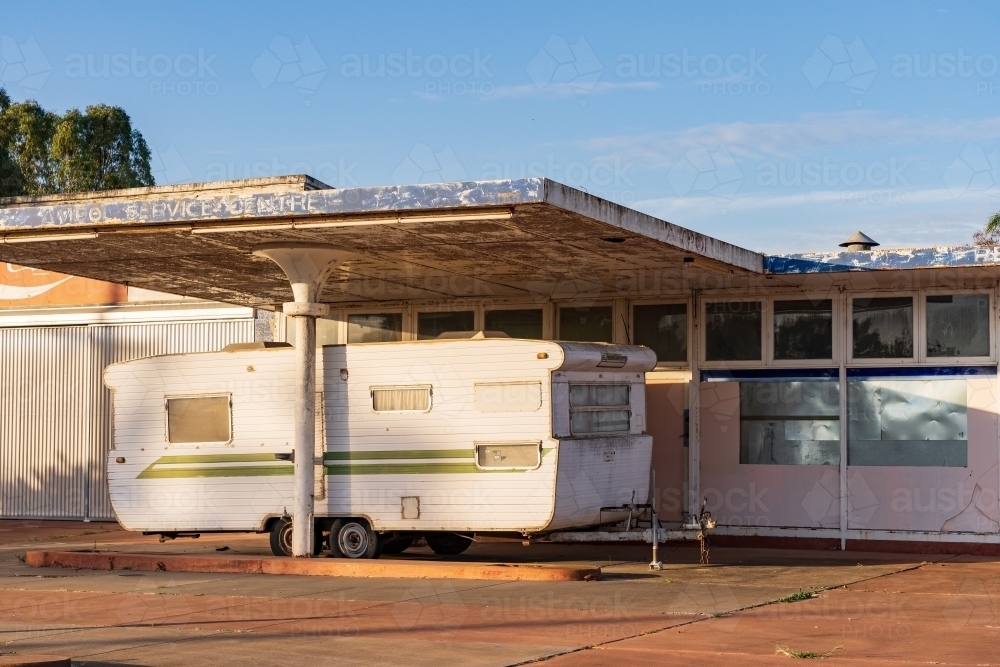 Image of A large retro style caravan parked under the canopy of an ...