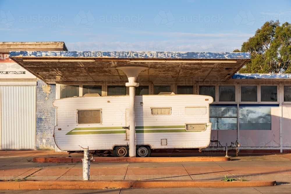 Image of A large retro style caravan parked under the canopy of an ...