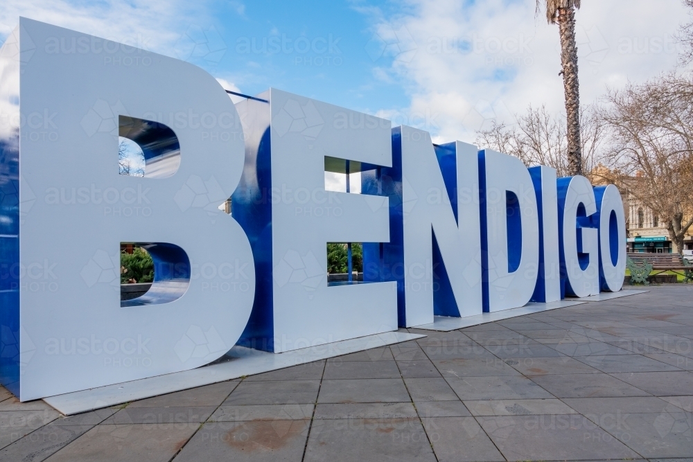 Image of A large sign made up of tall white letters sitting on a paved ...