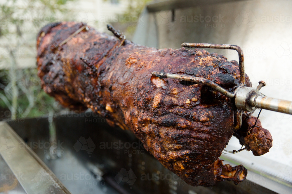 Image of a large spit roast cooking outdoors for a party - Austockphoto