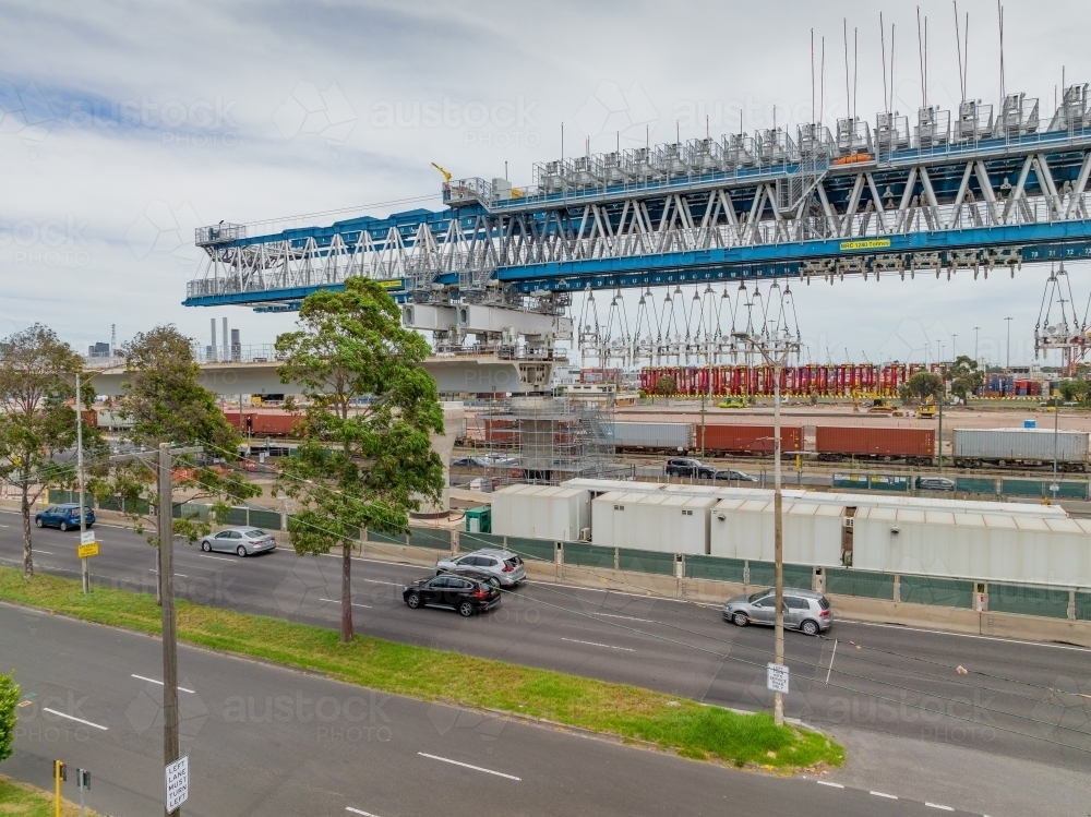 Image of A large suspension crane building an elevated freeway next to ...