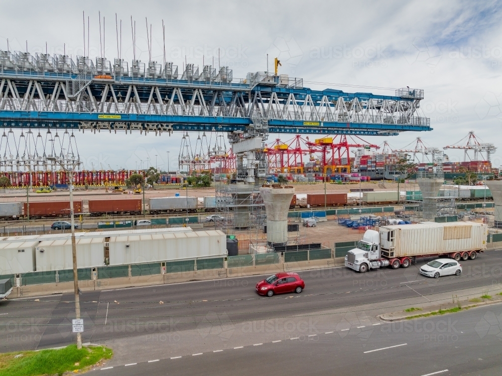 Image of A large suspension crane building an elevated freeway next to ...