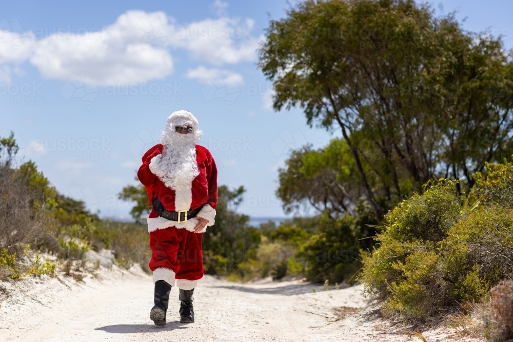 Image of a man dressed up as santa walking towards the camera outdoors ...