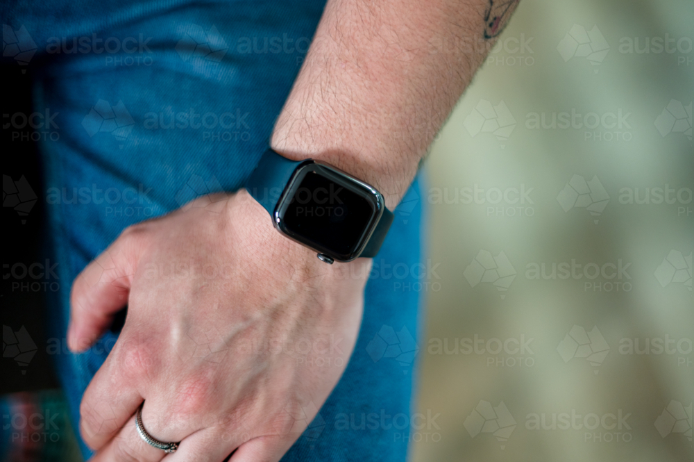 Image of A man in his 30s uses a smartwatch at home, highlighting ...