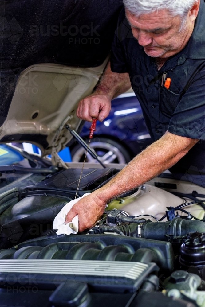 Image of A mechanic servicing a luxury car in his workshop on the Gold ...