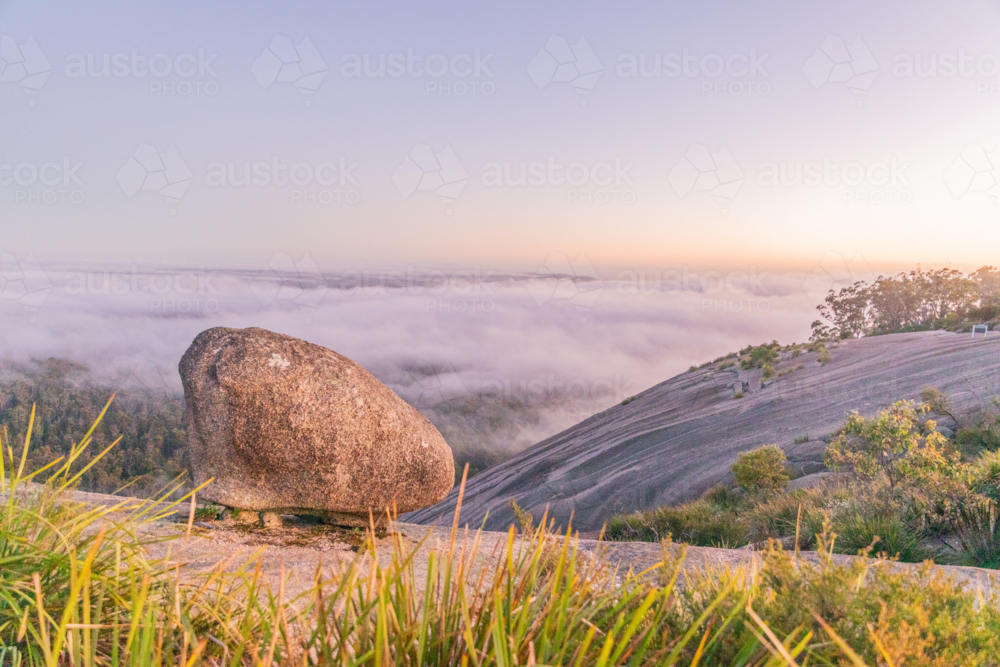 Image of A misty morning sunrise on a granite monolith - Austockphoto