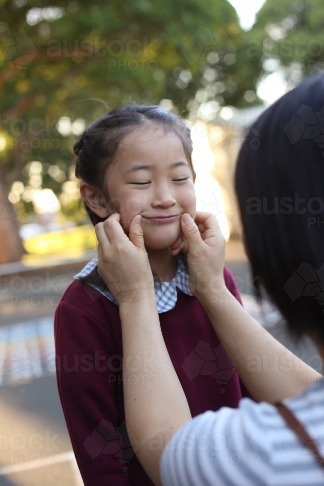 Image Of A Mother Pulling Her Daughters Cheeks In The School Playground Austockphoto