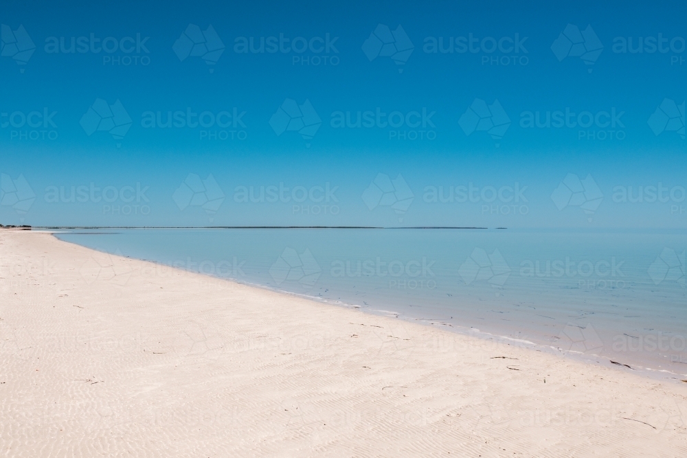 Image of a peaceful beach with white sand and calm blue water ...