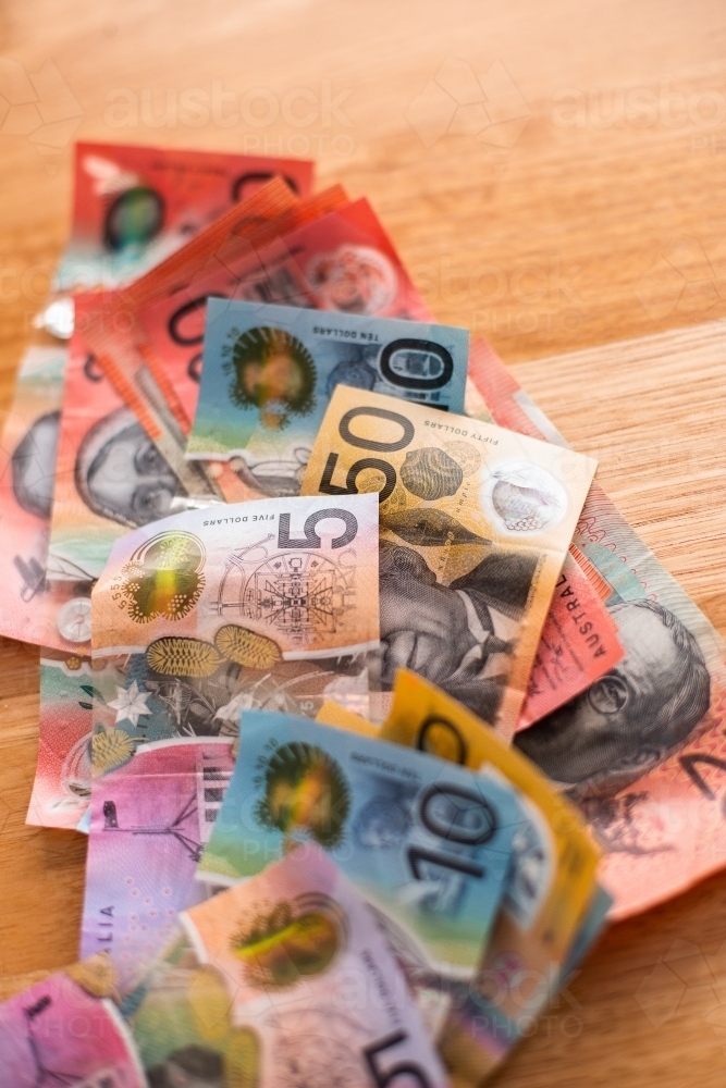 Image of a pile of assorted Australian note money on a table - Austockphoto